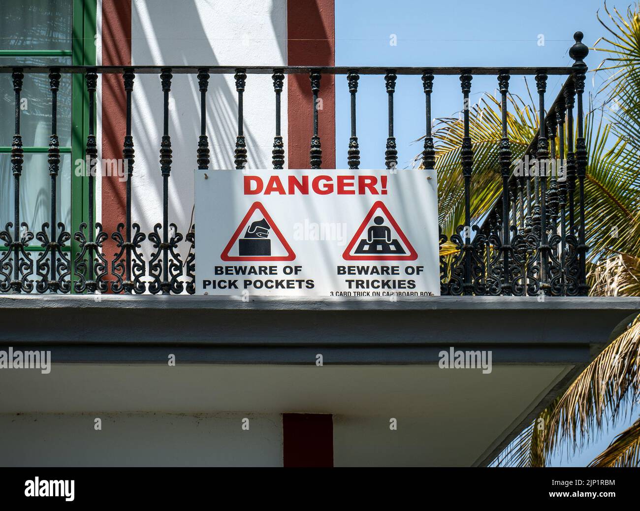 Warning on sign at villa about pickpockets and tricksters Stock Photo ...