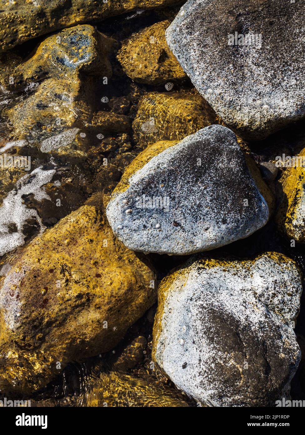 Wet stones partly covered with a sea water Stock Photo - Alamy