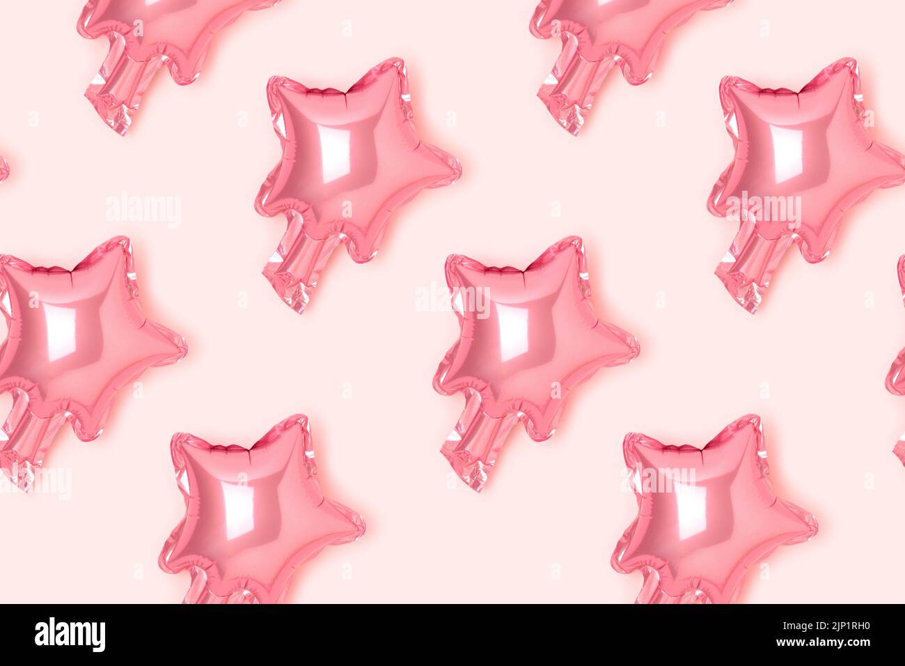 Repetitive pattern made from pink star foil balloon. Creative layout ...