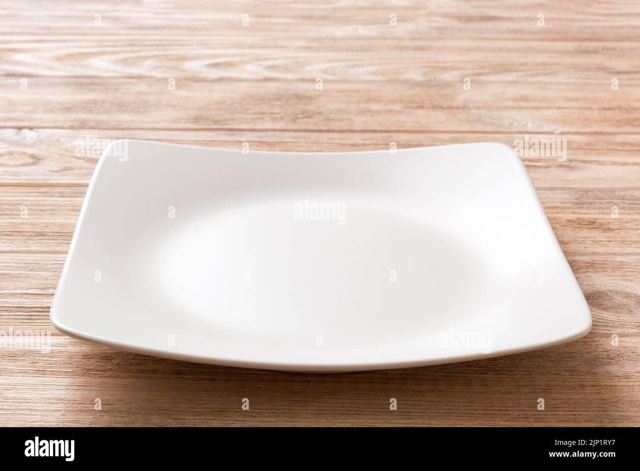 Perspective view of empty square plate on wooden background. Empty ...