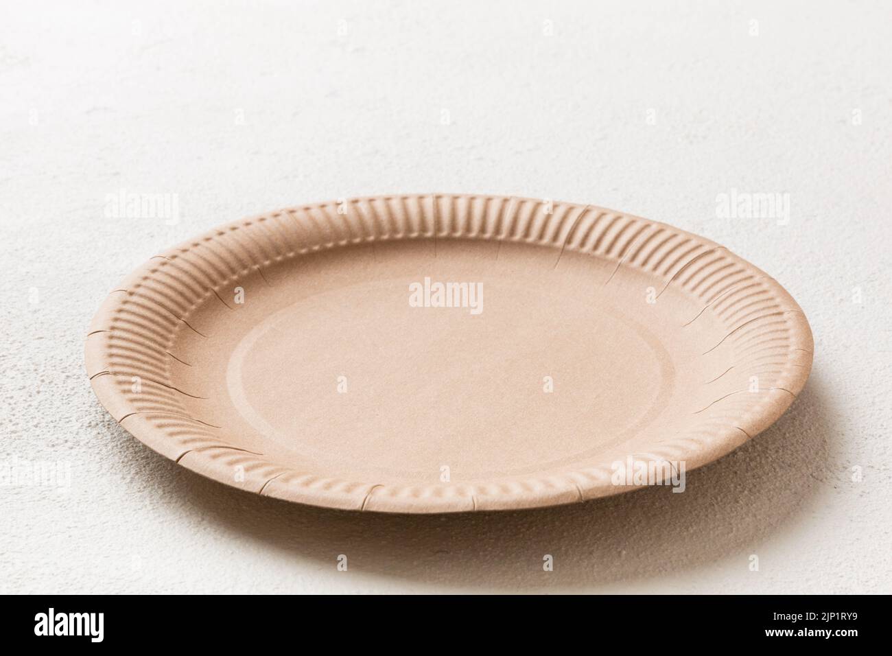 Perspective view of eco paper plate on cement background. Empty space ...