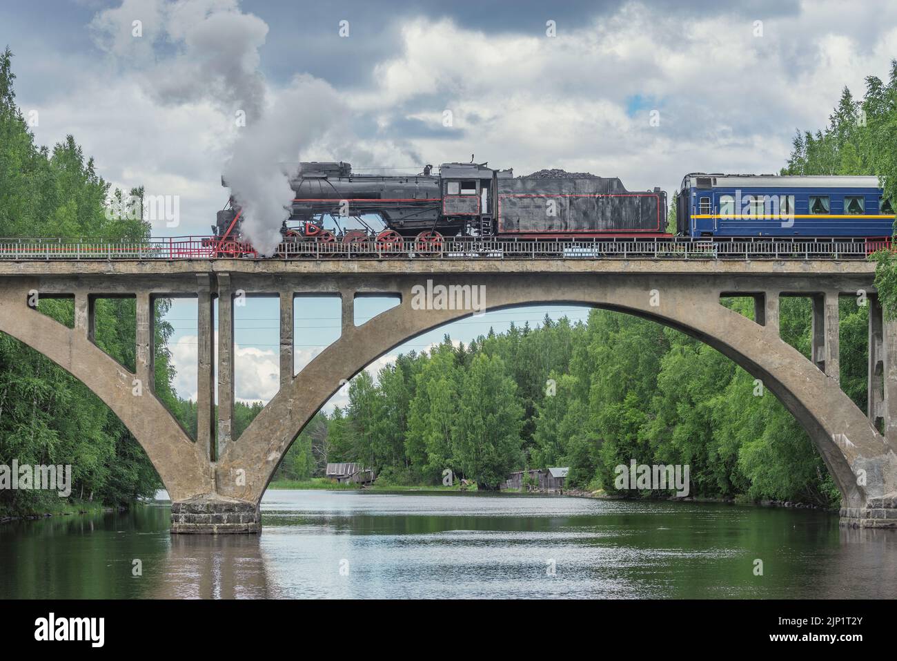 Retro steam train moves above the river Stock Photo - Alamy