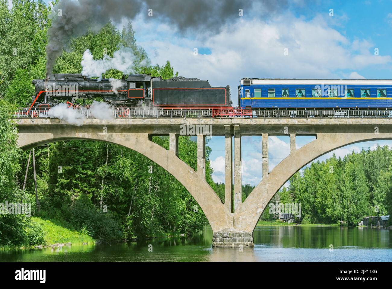 Retro steam train moves above the river Stock Photo - Alamy
