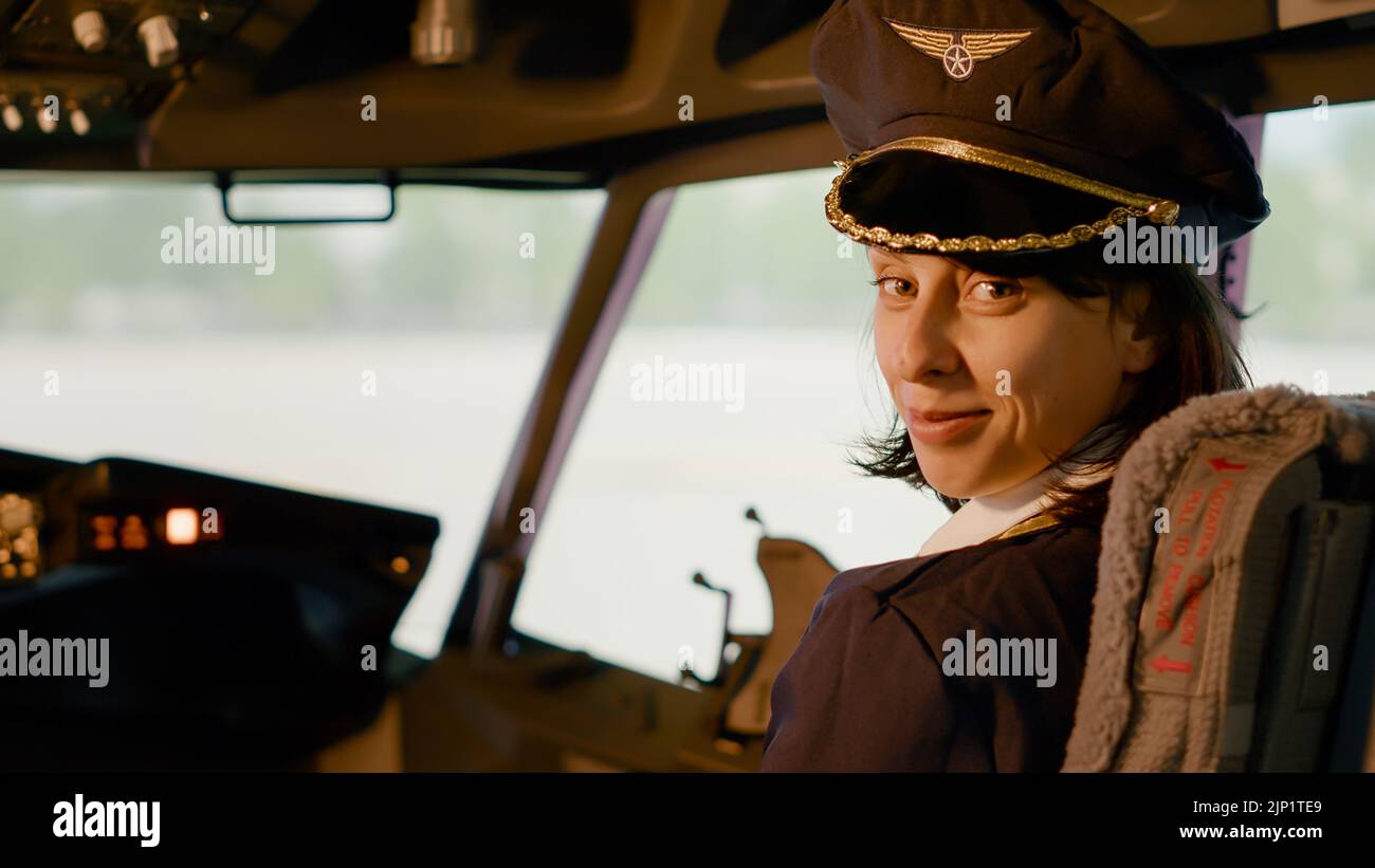 Portrait of female copilot in aviation uniform flying airplane from ...