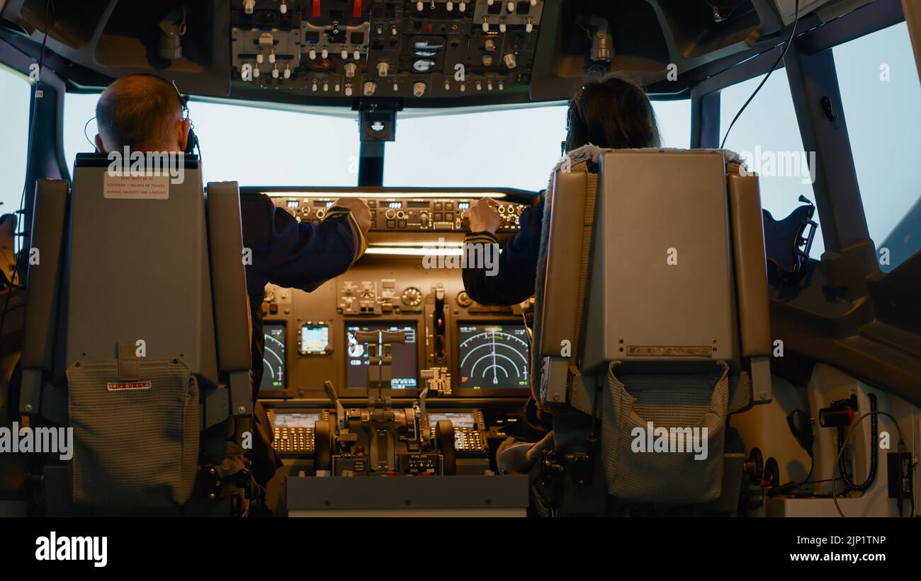 Plane captain and woman copilot fixing altitude on dashboard, using ...