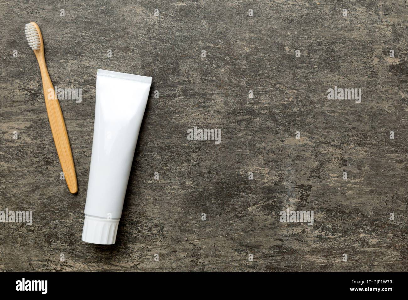 toothpaste and toothbrush top view with copy space on colored ...