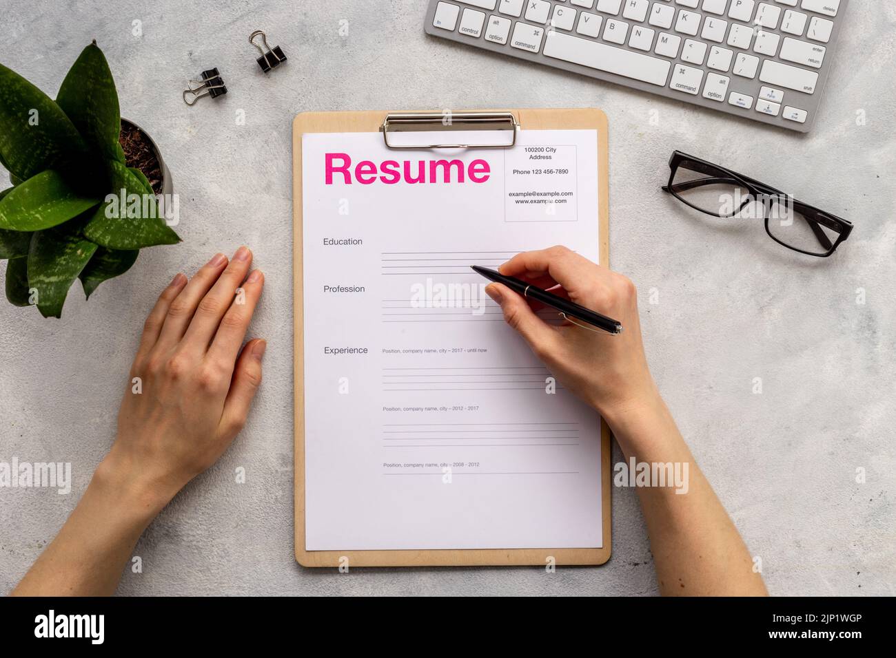 Hands with resume application form on office table. Find new job ...