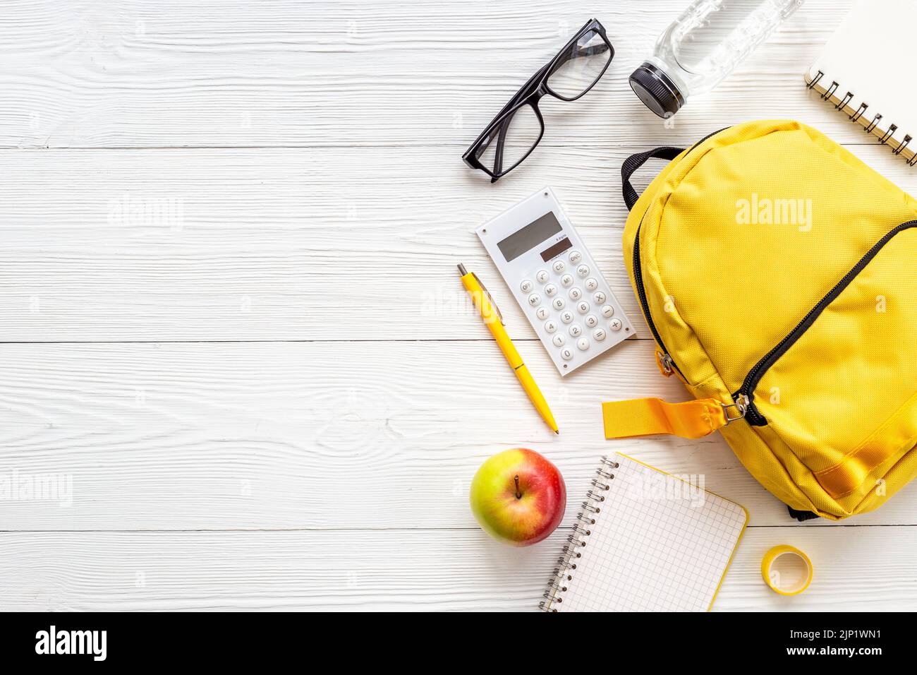 Students supplies in yellow school backpack. Back to school concept ...