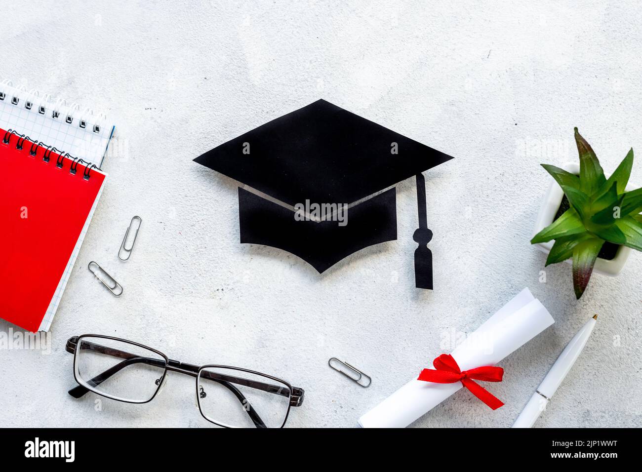 Graduation hat on students table. Masters or Bachelors degree concept ...