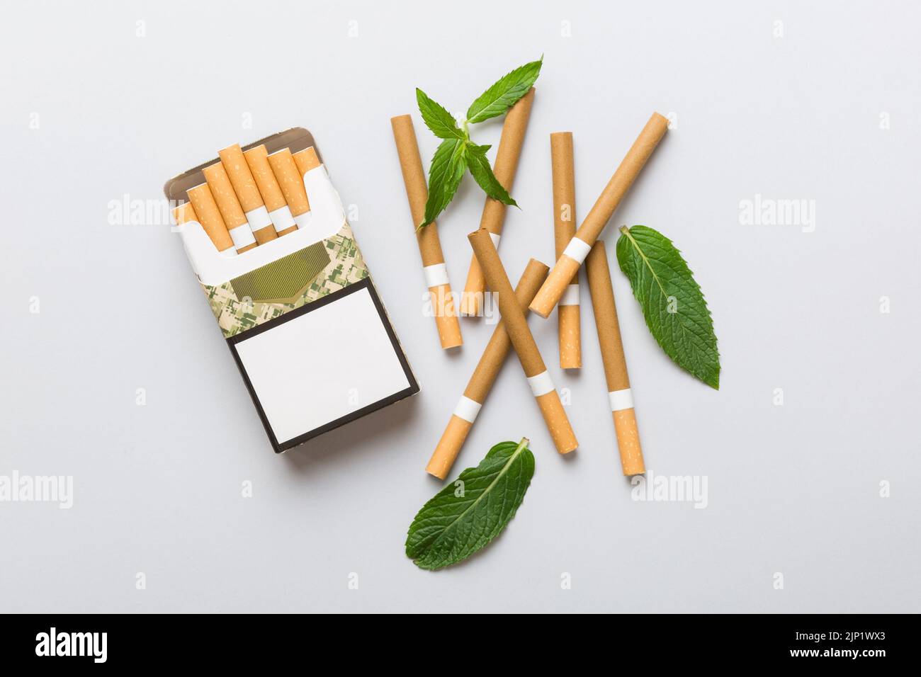Pack of menthol cigarettes and fresh mint on colored table, Menthol ...