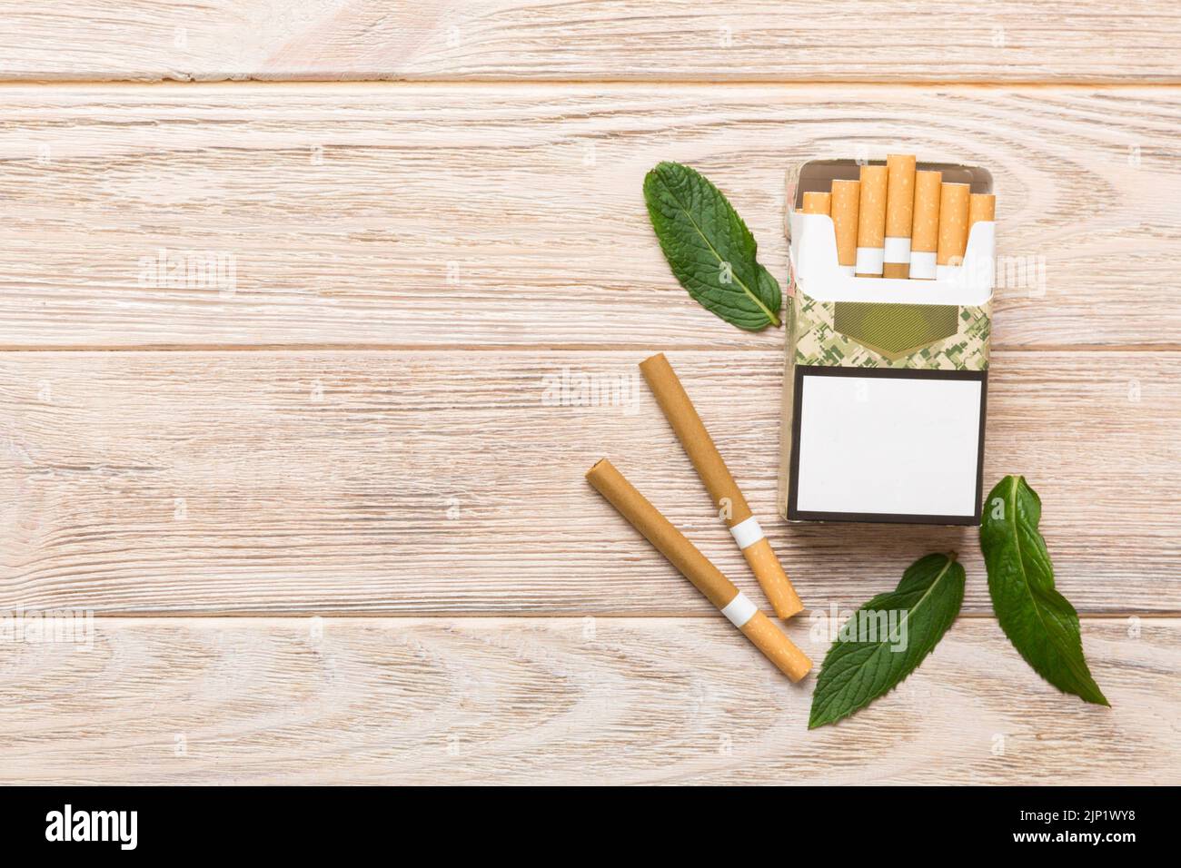 Pack of menthol cigarettes and fresh mint on colored table, Menthol ...