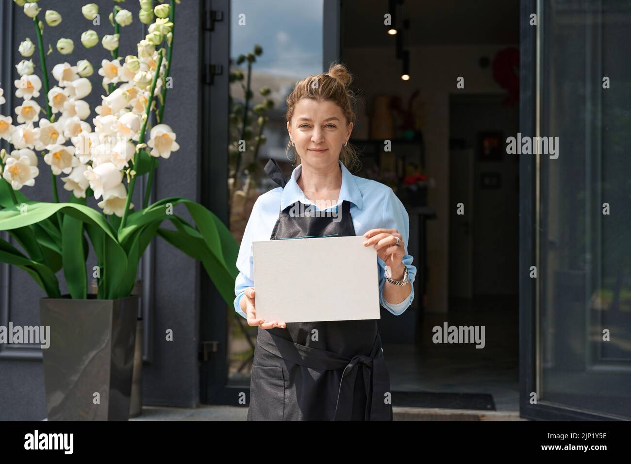 Portrait of charming florist standing in front of flower shop Stock ...