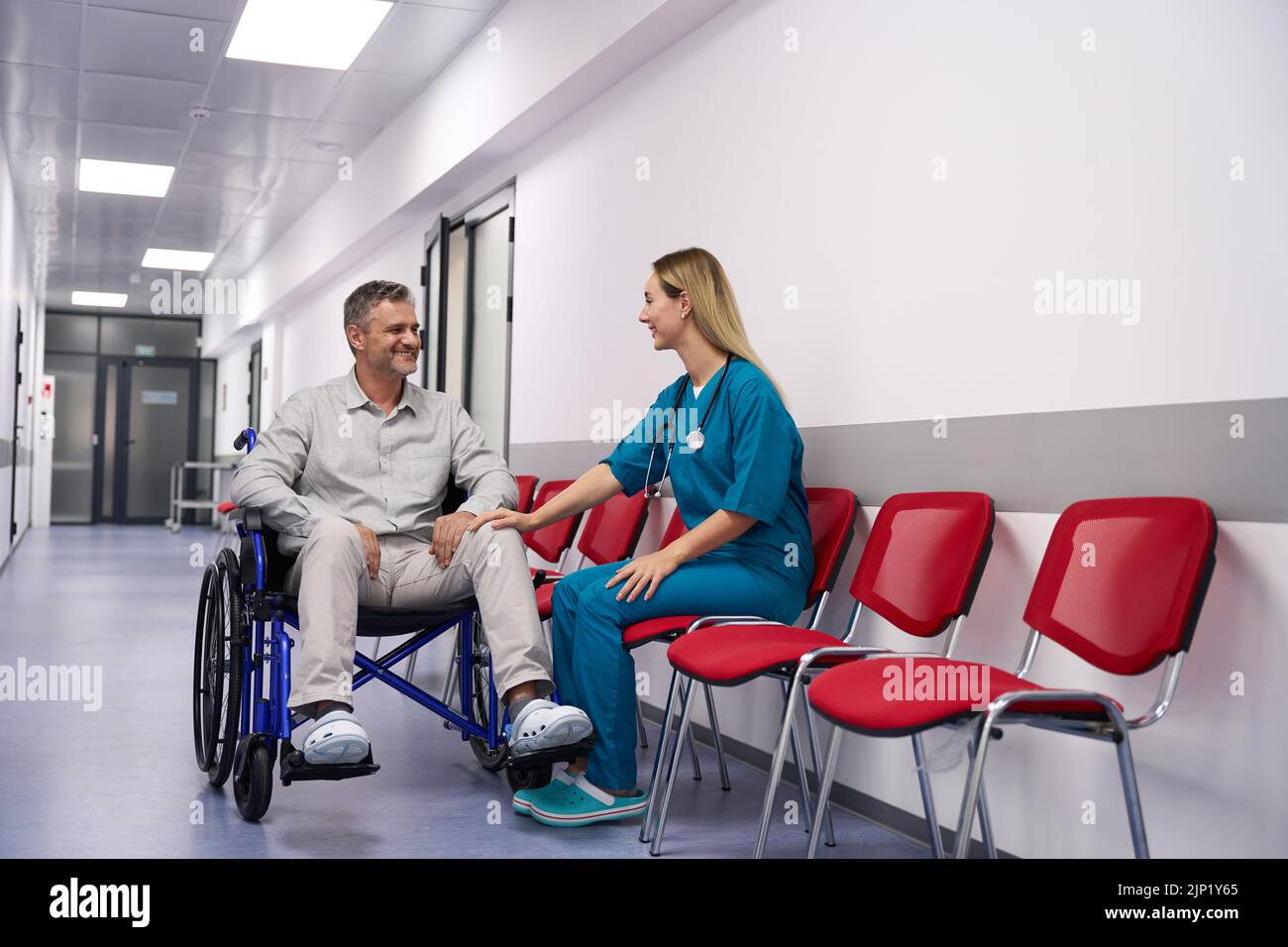 Pretty patient in a wheelchair and a female doctor having a cute ...