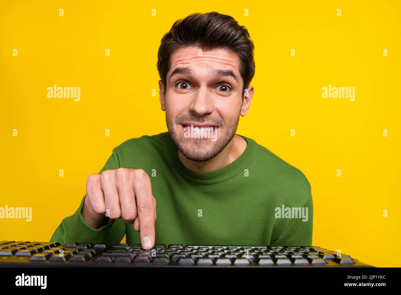 Portrait of attractive funny worried guy nerd pressing button using ...