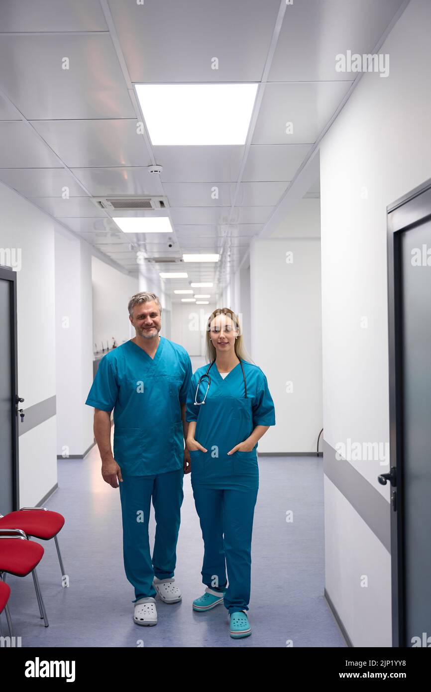Two doctors stand in the corridor and look at the camera smiling Stock ...