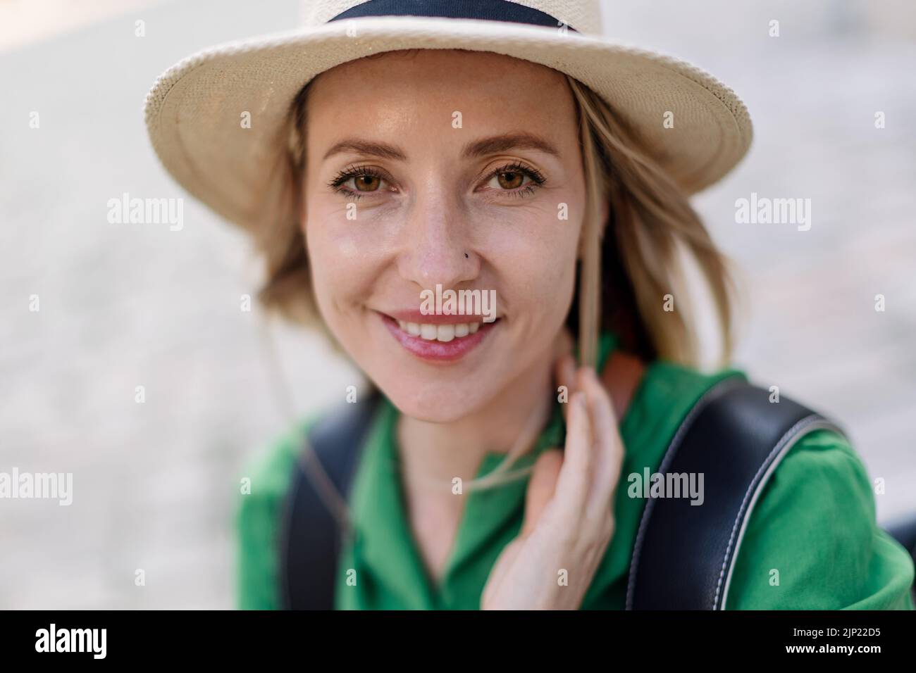 Portrait of young woman traveler, sitting, resting, smiling and looking ...