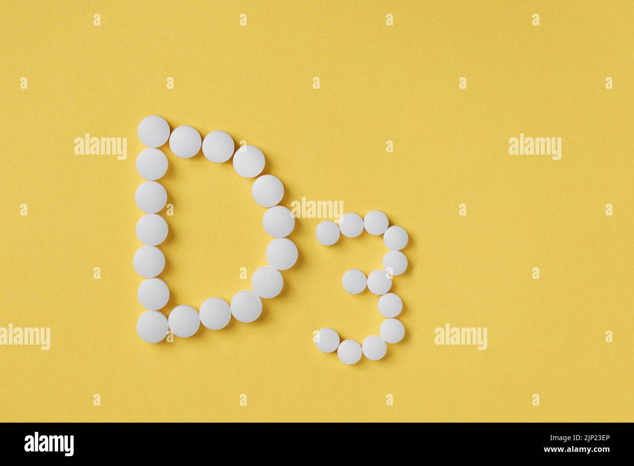 Pills of vitamin D3 on yellow background top view. Concept of vitamin ...