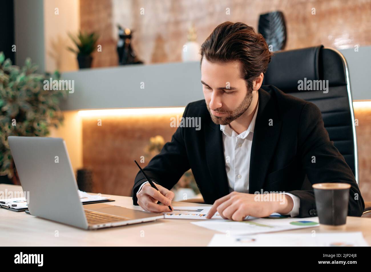 Concentrated clever caucasian business man, IT specialist, ceo, sits at ...