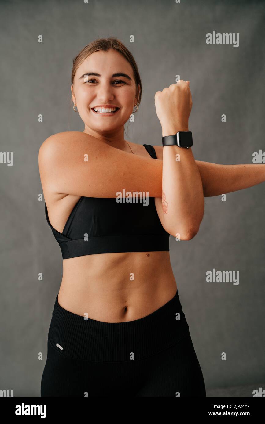 Happy smiling woman doing arm stretching warm up Stock Photo - Alamy