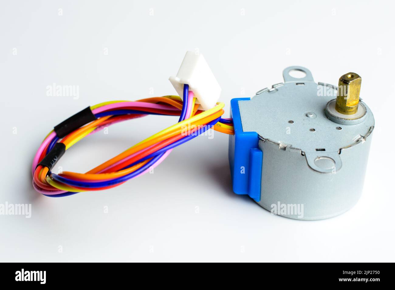 Electronic stepper motor with colorful wires on a white background ...