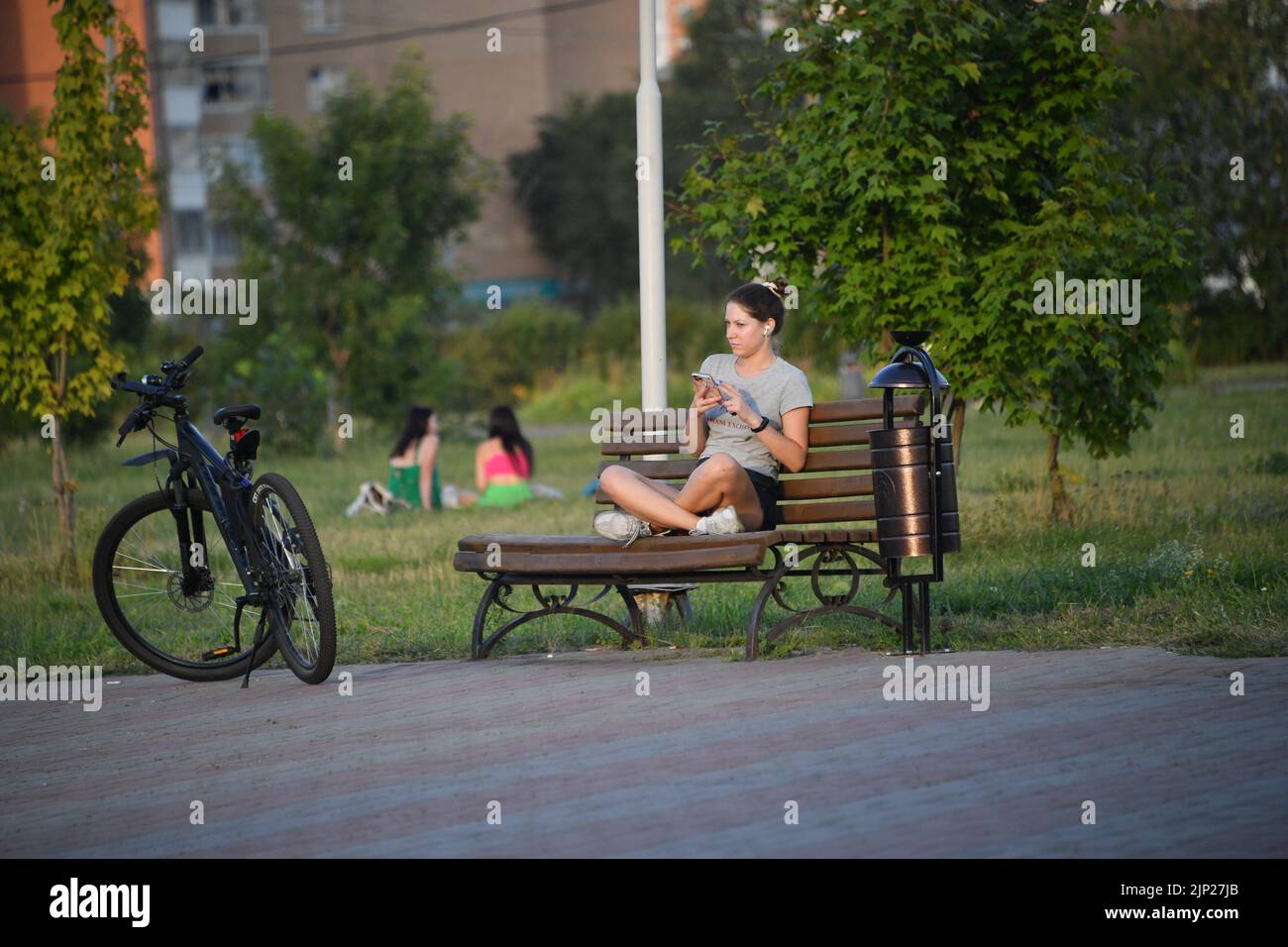 Moscow. Natural and historical Kosinsky park. The girl sits on a bench ...