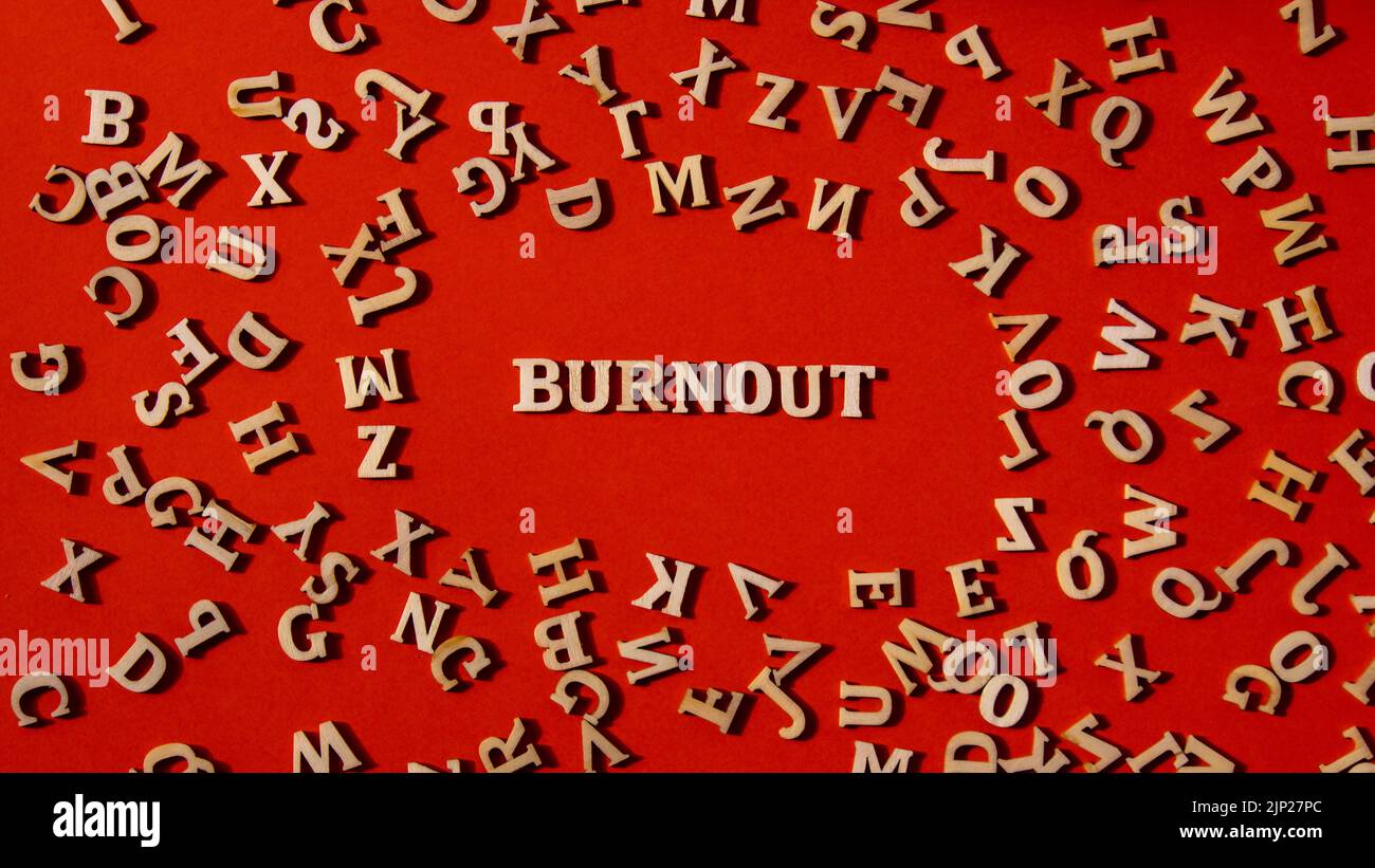 Word BURNOUT made out of wooden letters on bright red background ...