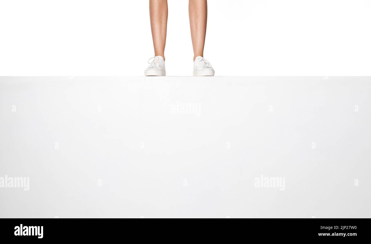 female legs in white sneakers on white banner Stock Photo - Alamy