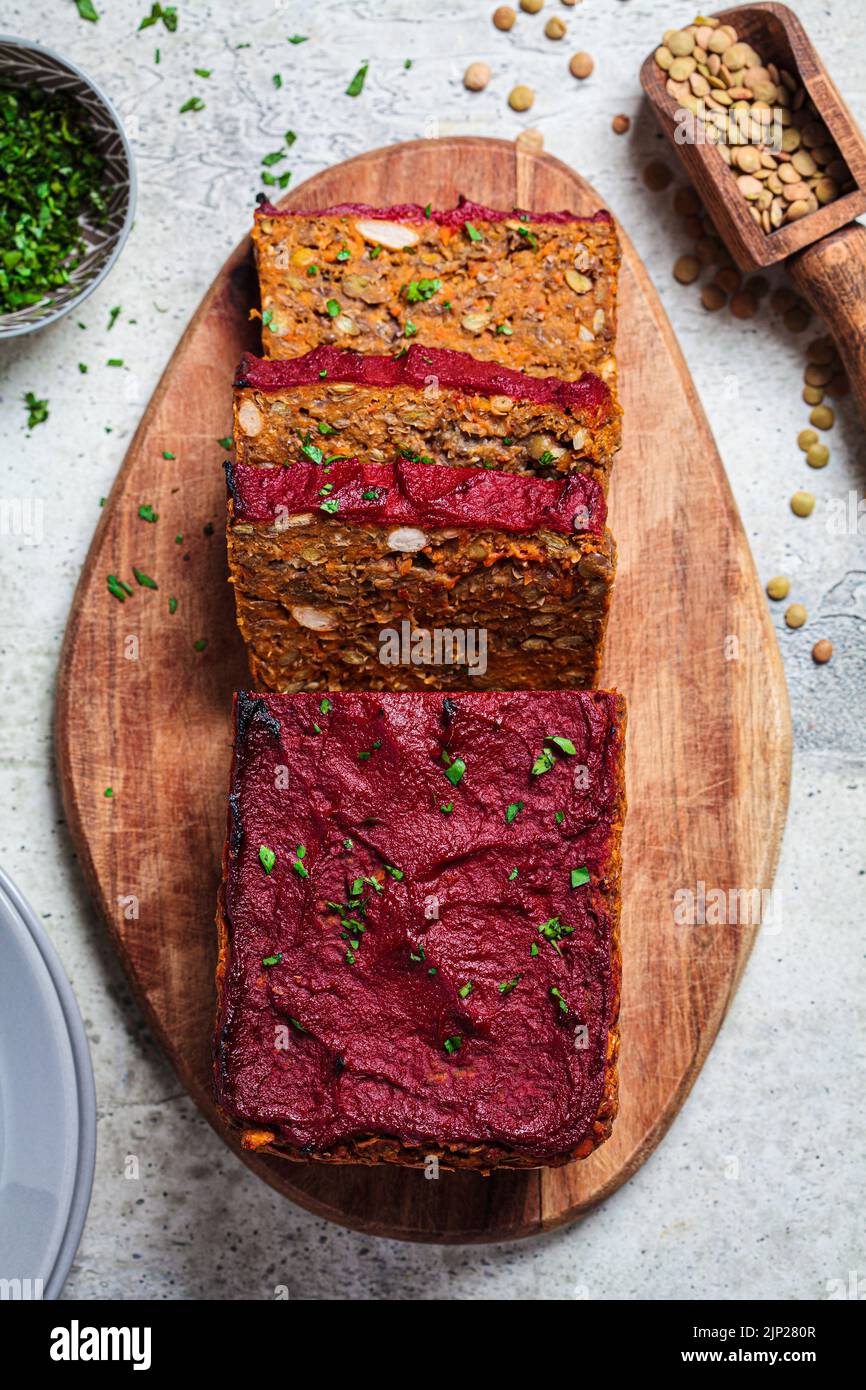 Lentil vegan meatloaf sliced on a wooden board, top view. Christmas ...