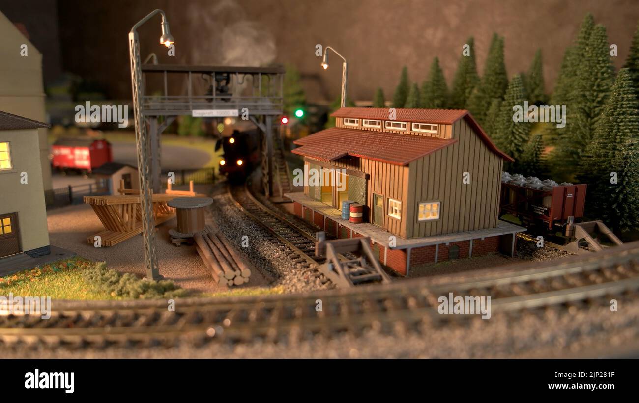 Toy diesel locomotive driving on railroad. Model railway station with ...