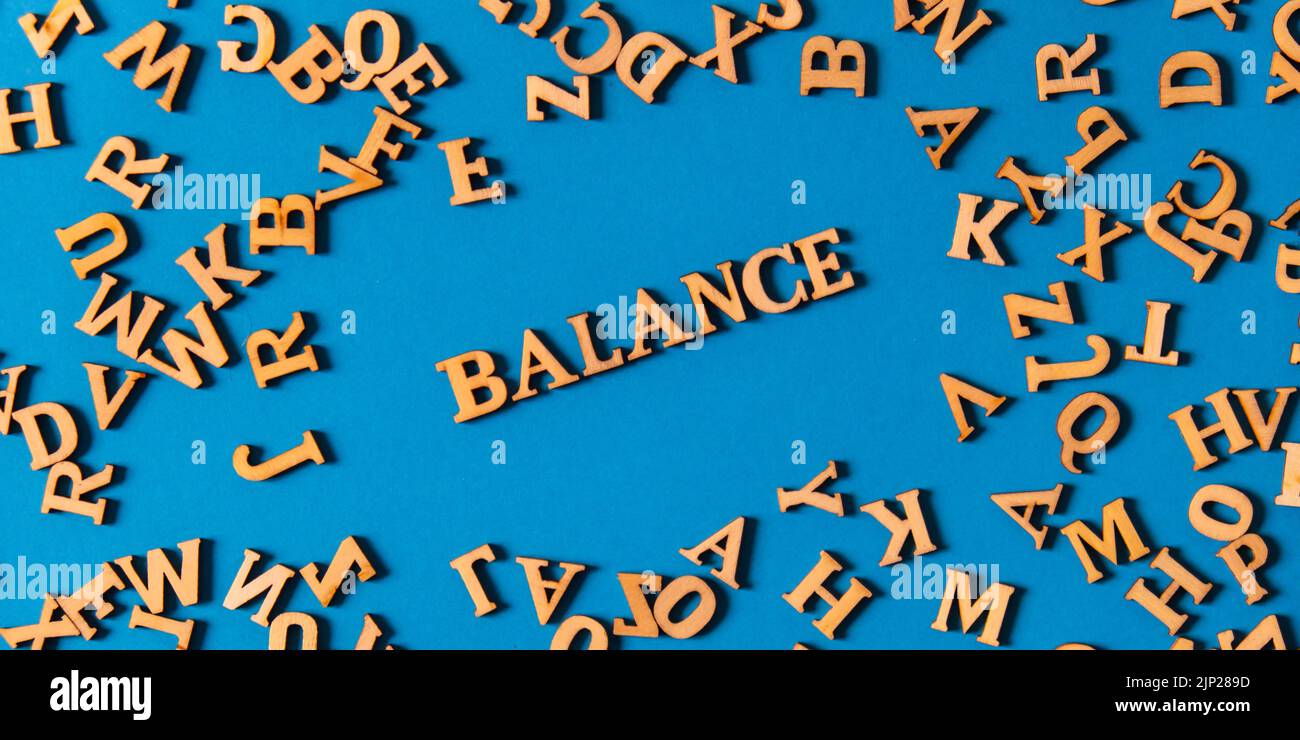 Word BALANCE made out of wooden letters on bright blue background ...