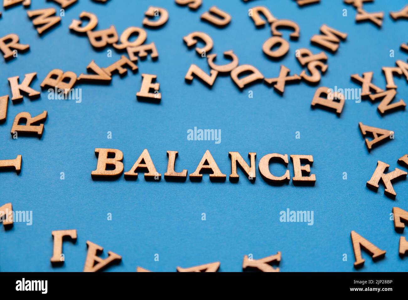 Word BALANCE made out of wooden letters on bright blue background ...