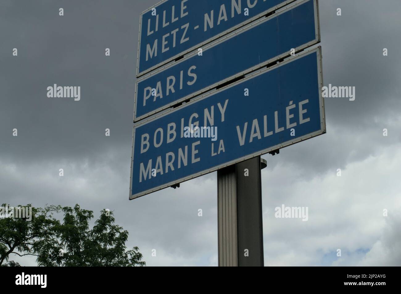 A sign pole with blue Paris sign Stock Photo - Alamy