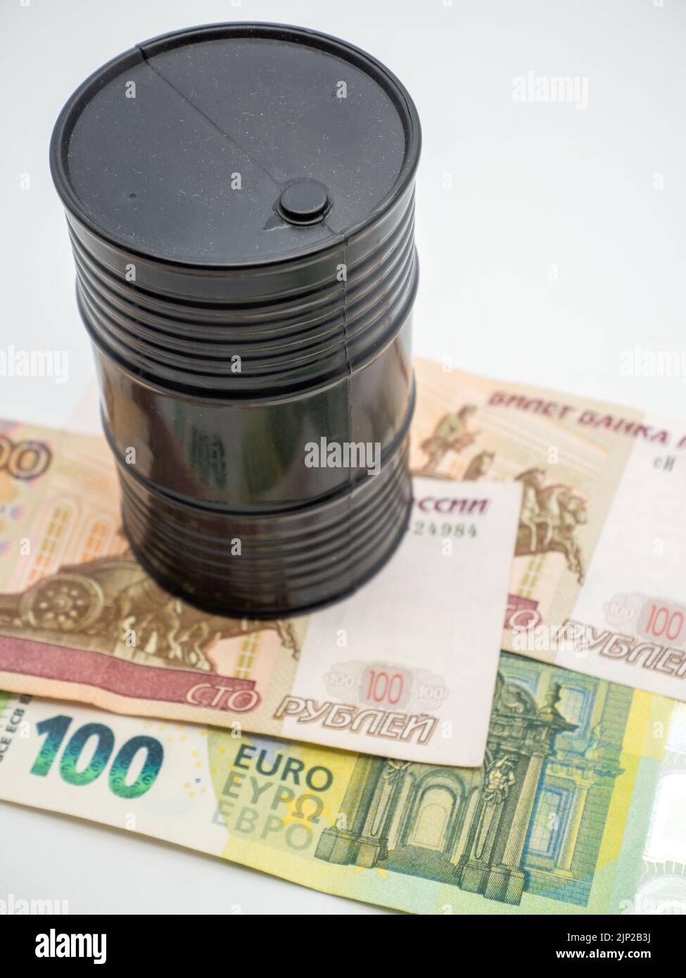 A small plastic oil barrel on paper money on white table - black gold ...