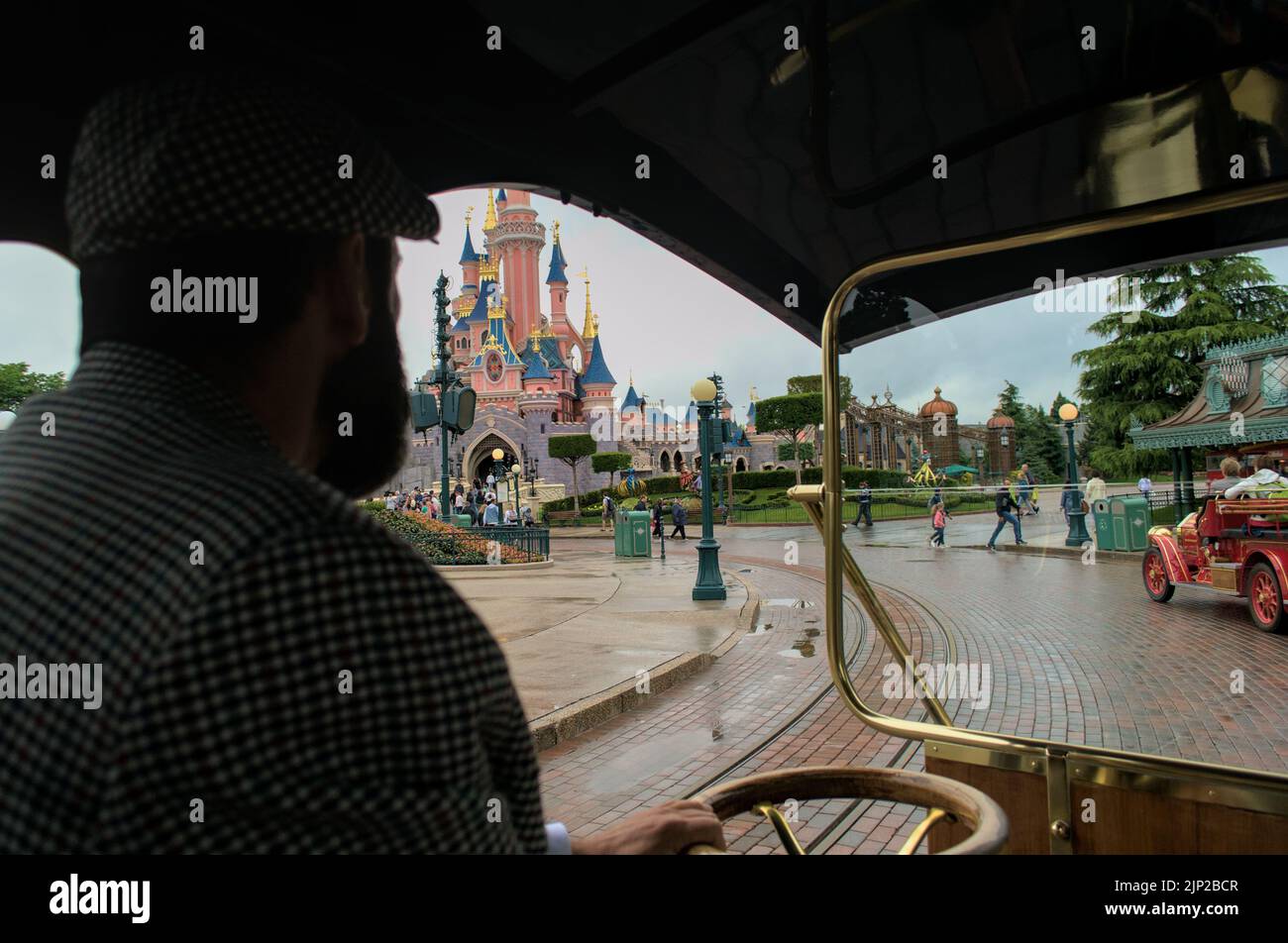 An adult male driving in Disneyland with the view of the 30th ...