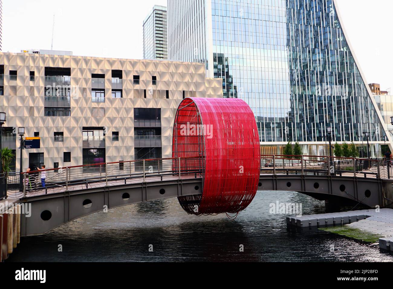 The Canary Wharf bridge reflected in the water Stock Photo - Alamy
