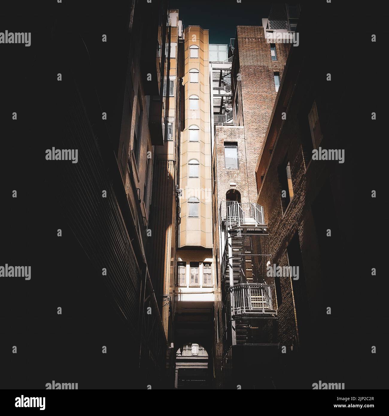 A tall residential building from a narrow passage Stock Photo - Alamy