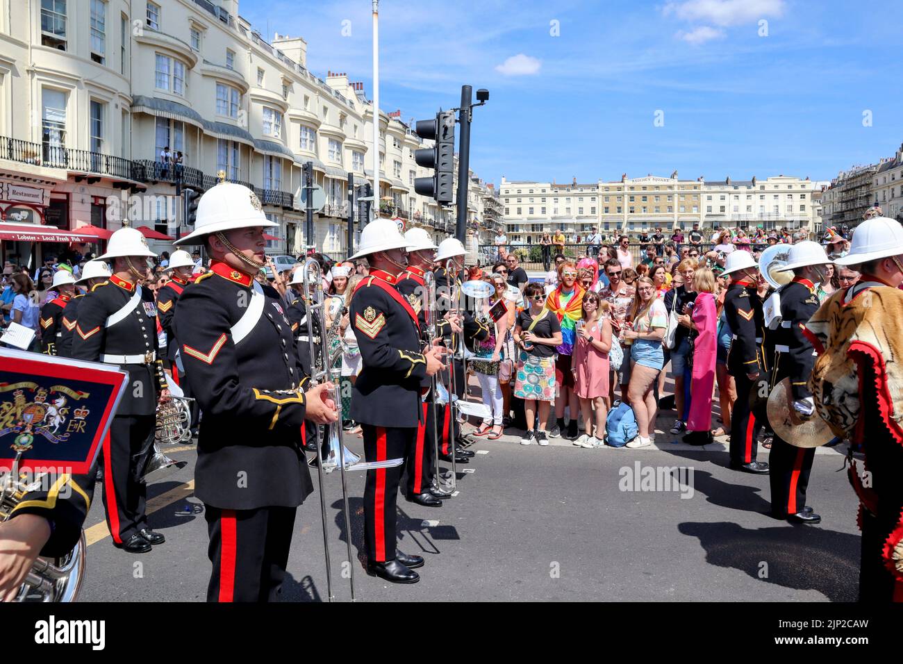 A band at Brighton Pride Parade while people are walking on the streets ...