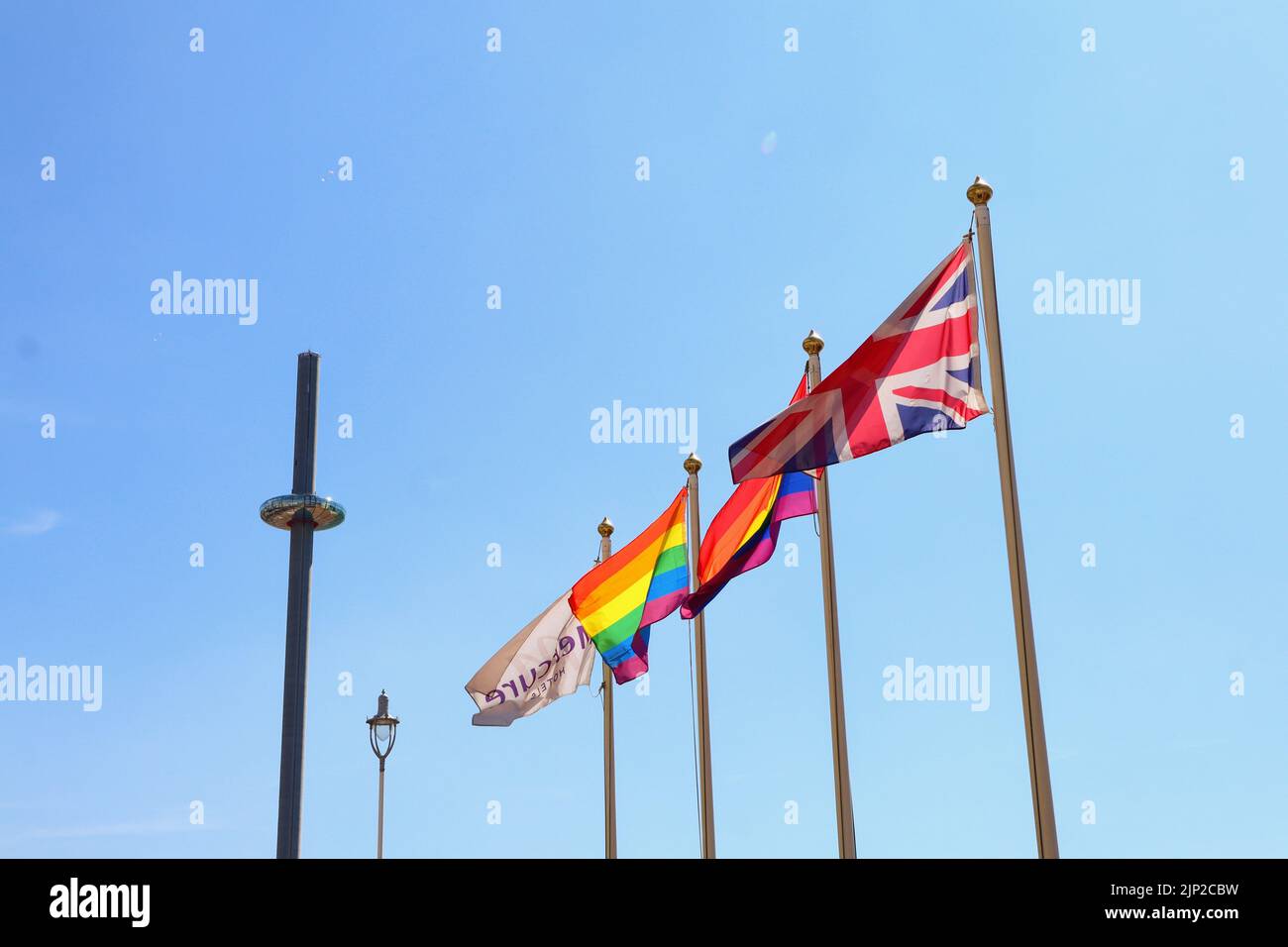 The LGBTQ and UK flags at the pole with blue sky background Stock Photo ...