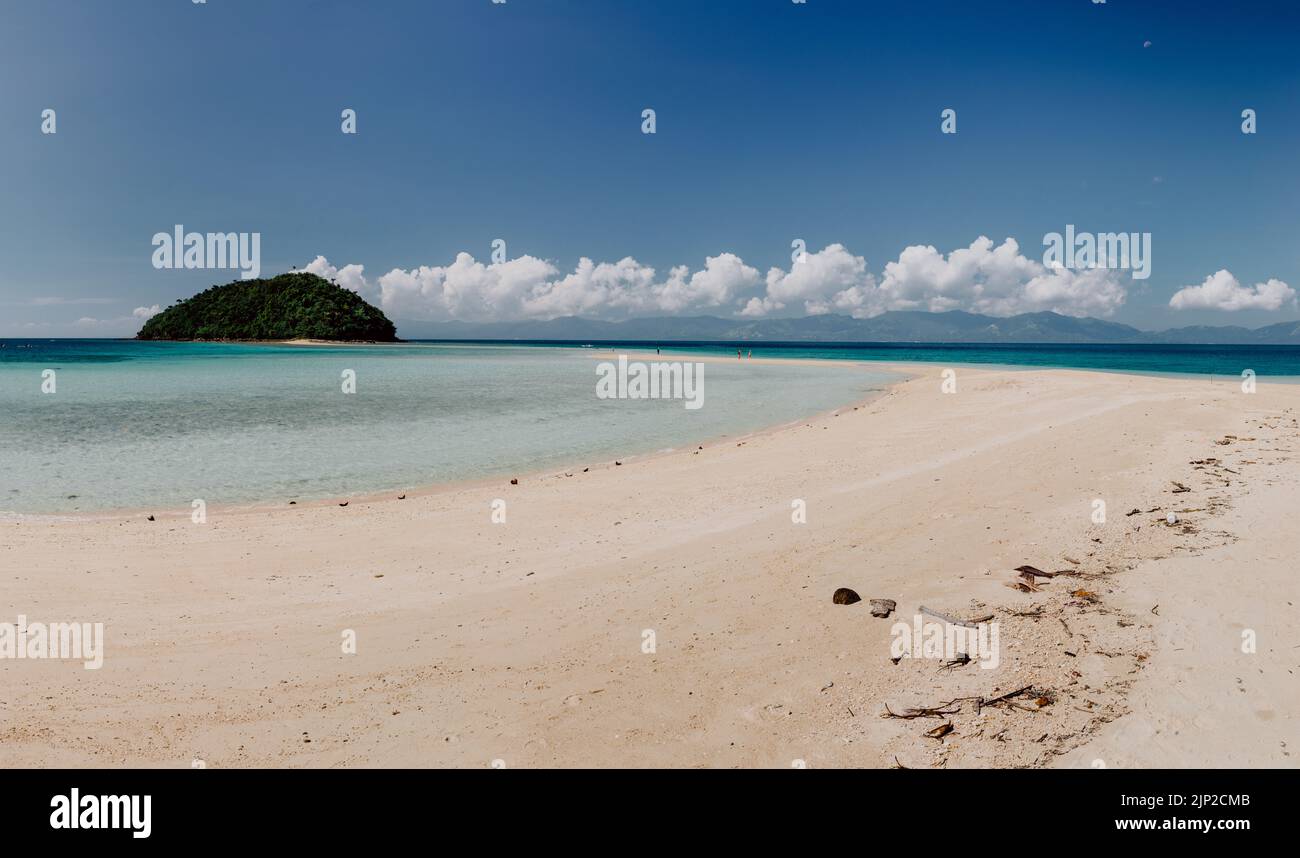 A mesmerizing view of the sandy Bon Bon Beach and a cliff with dense ...