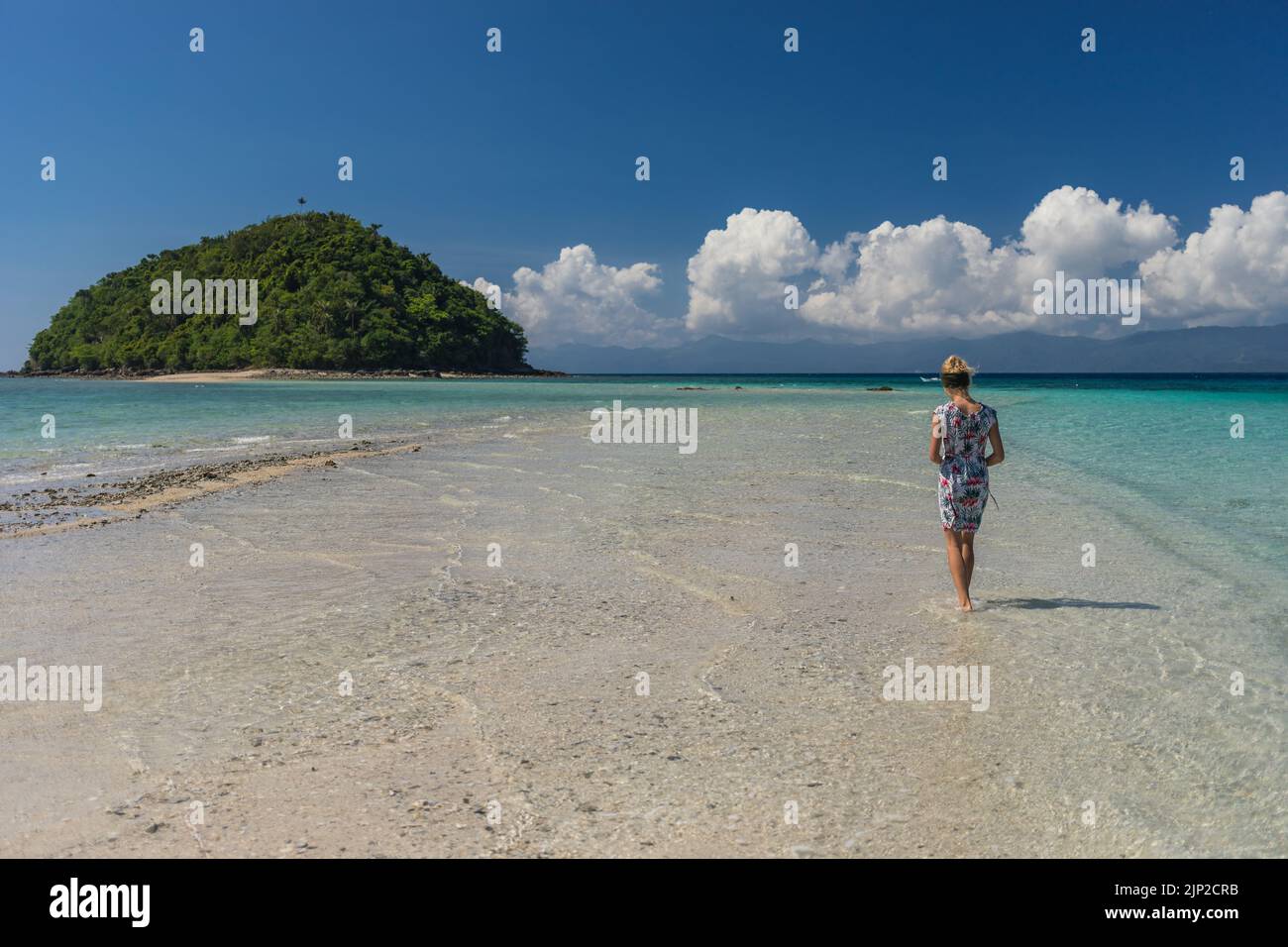 A blue sky over an island with a man on blue ocean water Stock Photo ...