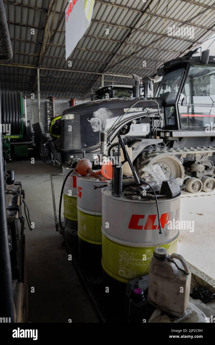 Some metal barrels of class oil fuel in warehouse with tools on top of ...