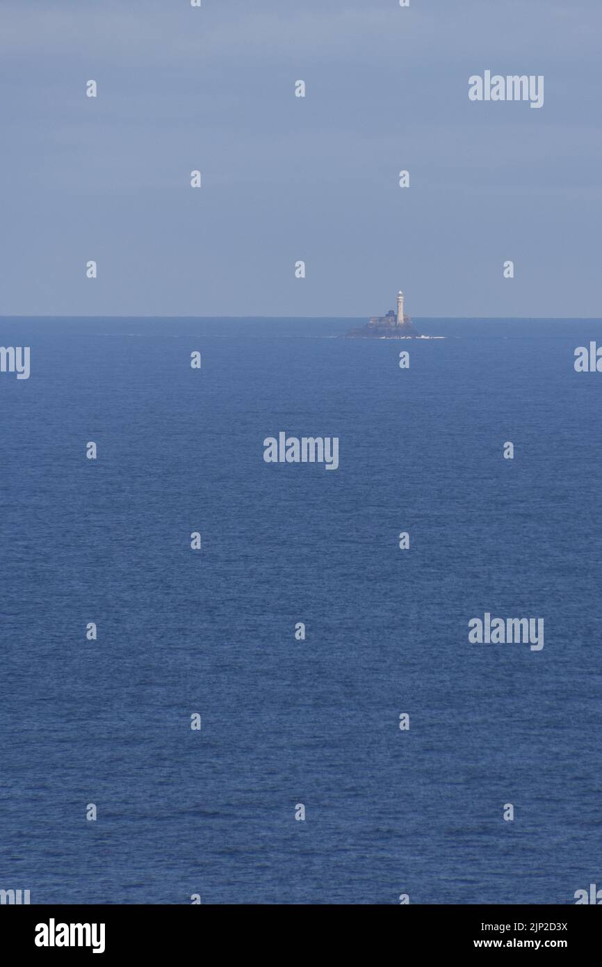 A vertical view of a small boat in the sea from a shore in Ireland ...