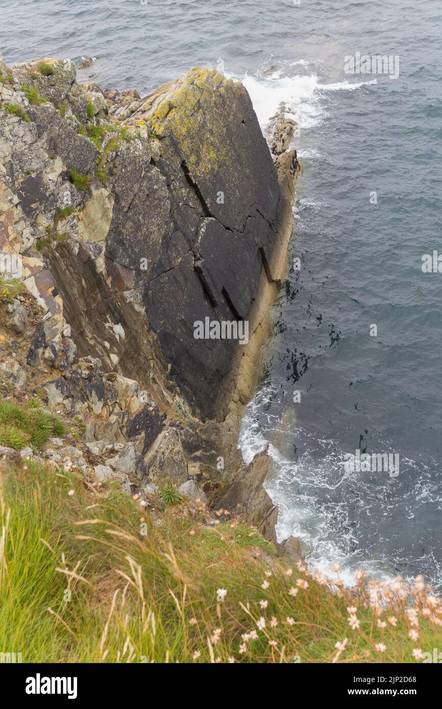 A vertical shot of a high cliff near a sea shore in Ireland, United ...