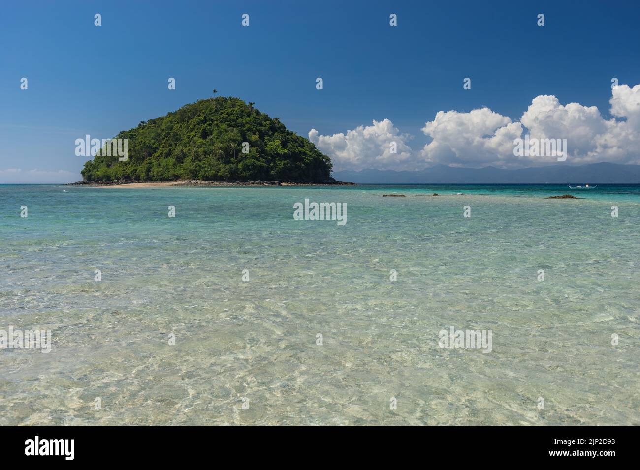 A mesmerizing view of the sandy Bon Bon Beach and a cliff with dense ...