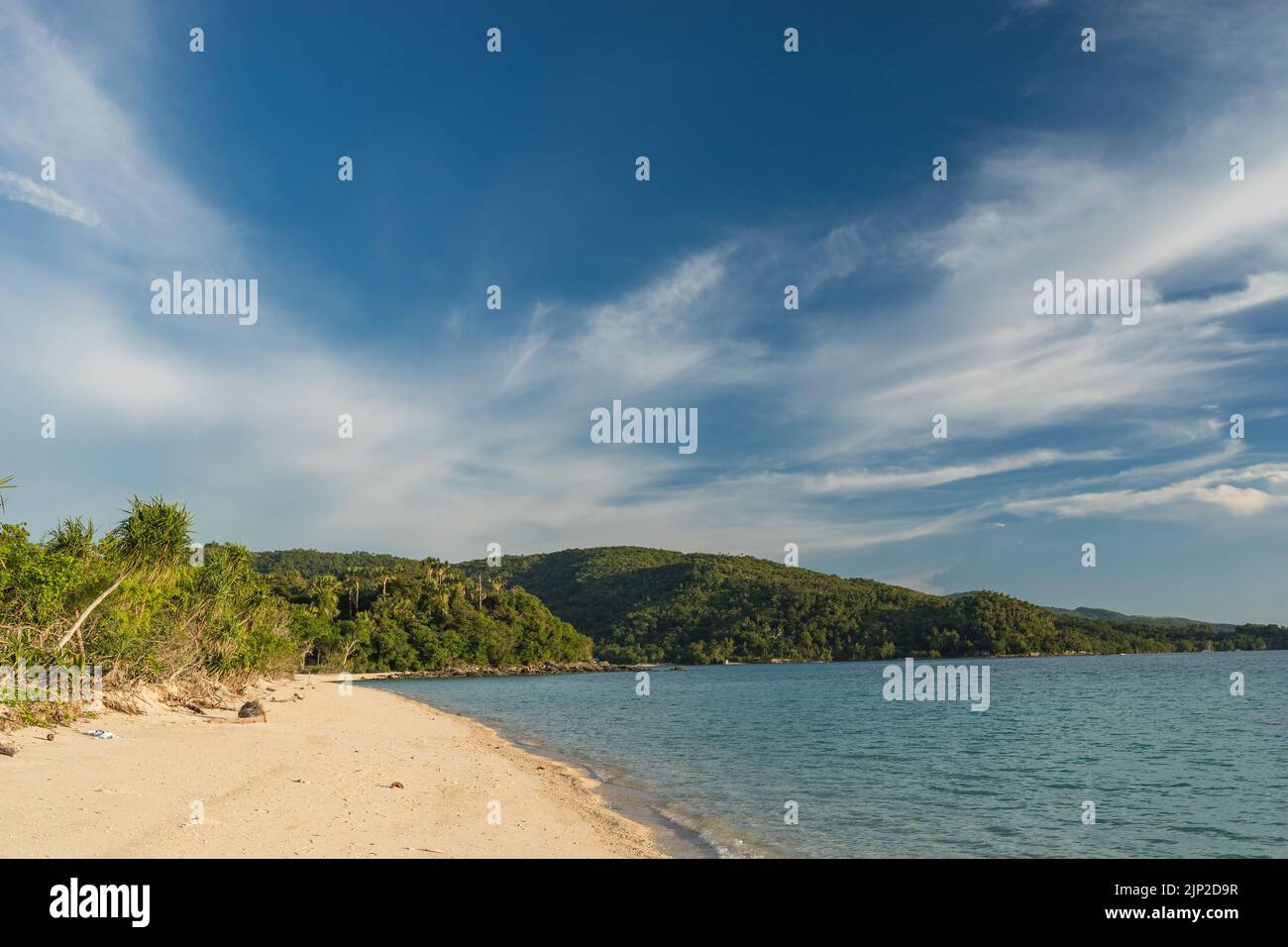 A mesmerizing view of the sandy Bon Bon Beach and a mountain with dense ...