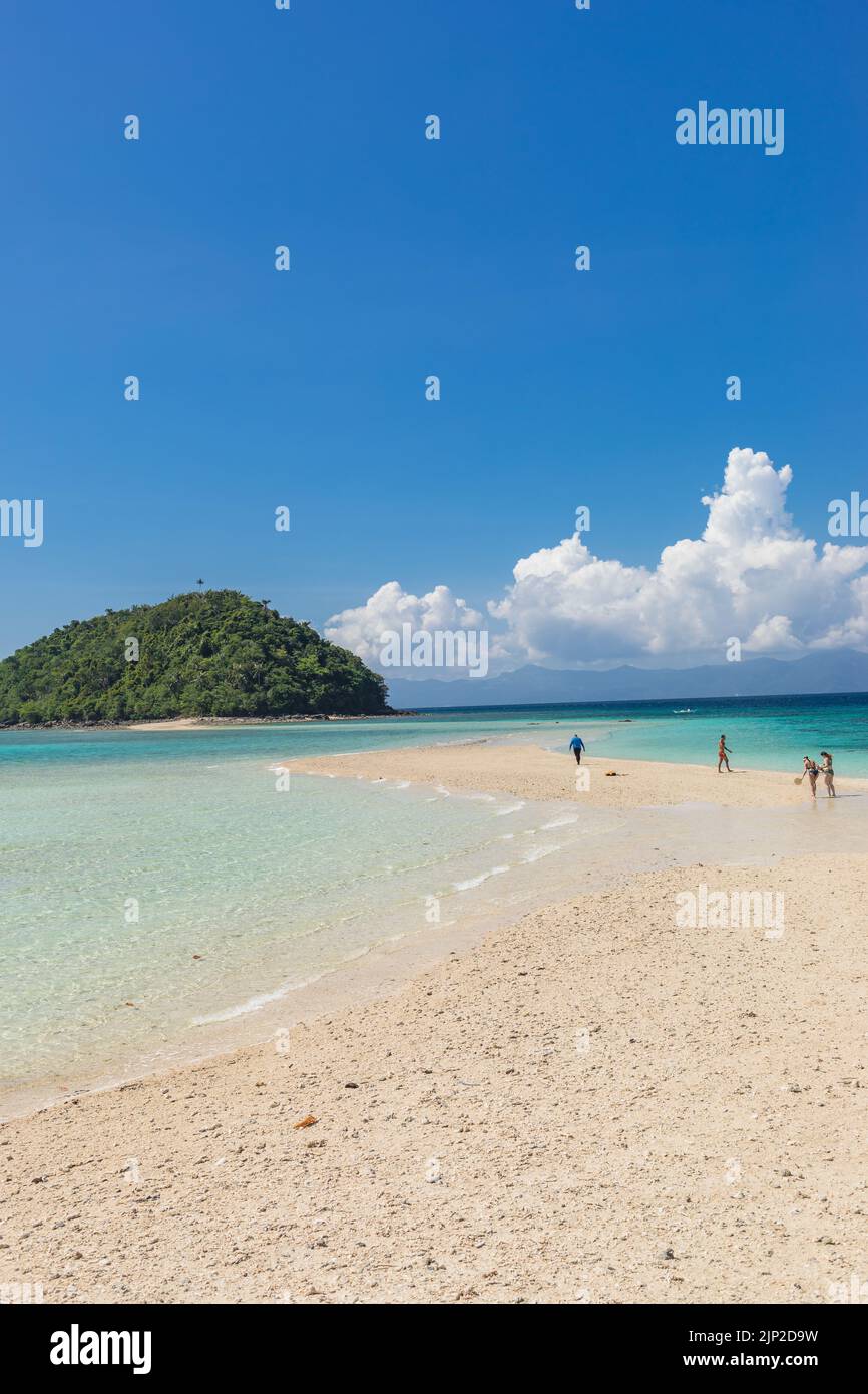 A mesmerizing view of the sandy Bon Bon Beach and a cliff with dense ...