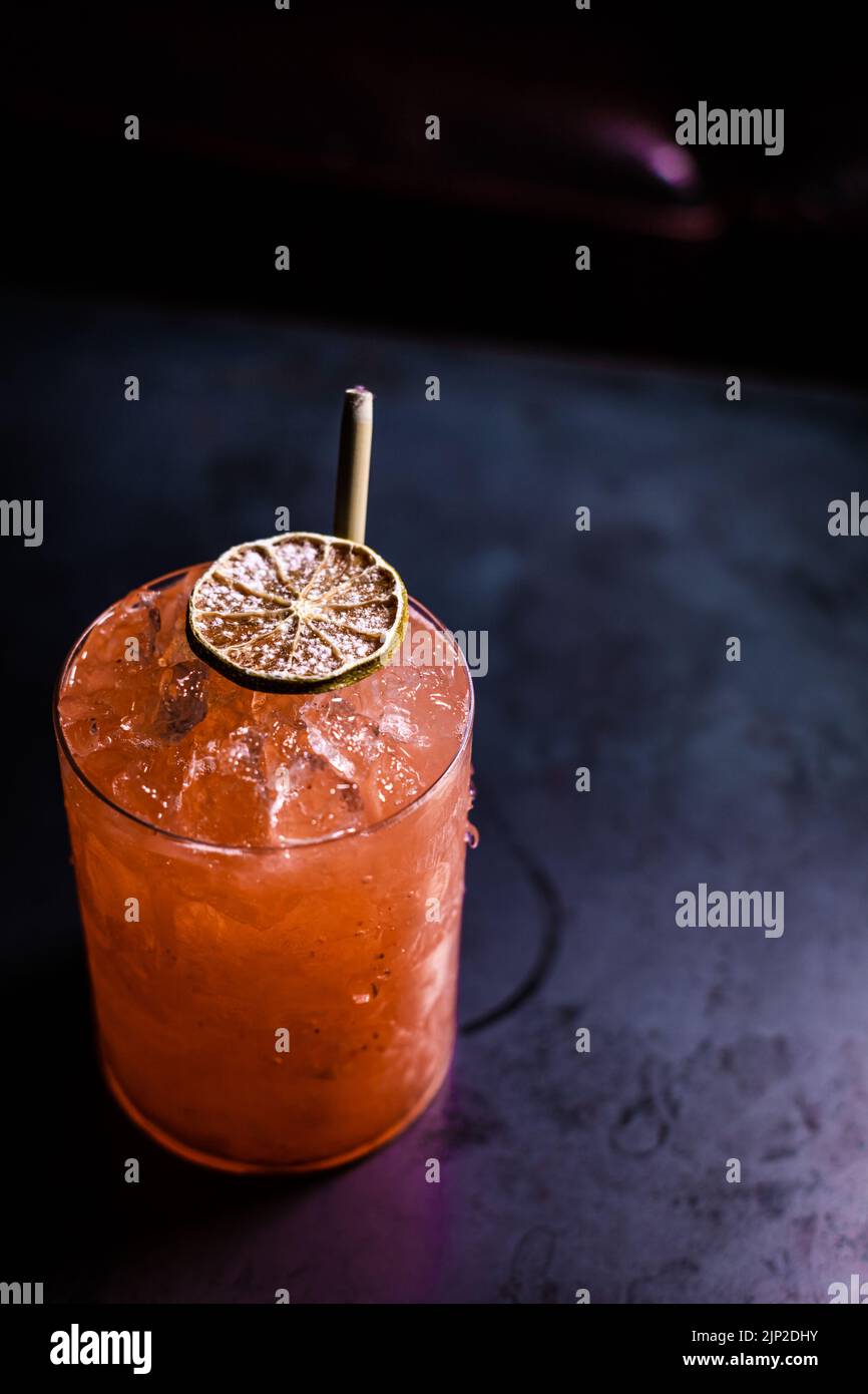 A vertical shot of a luxurious delicious fancy citrus cocktail on a bar ...