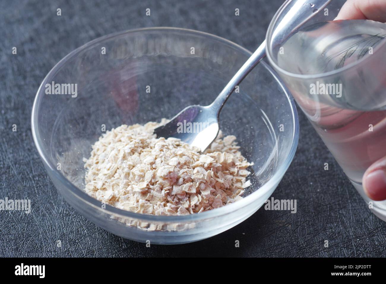 putting water in raw oats flakes in a bowl Stock Photo - Alamy