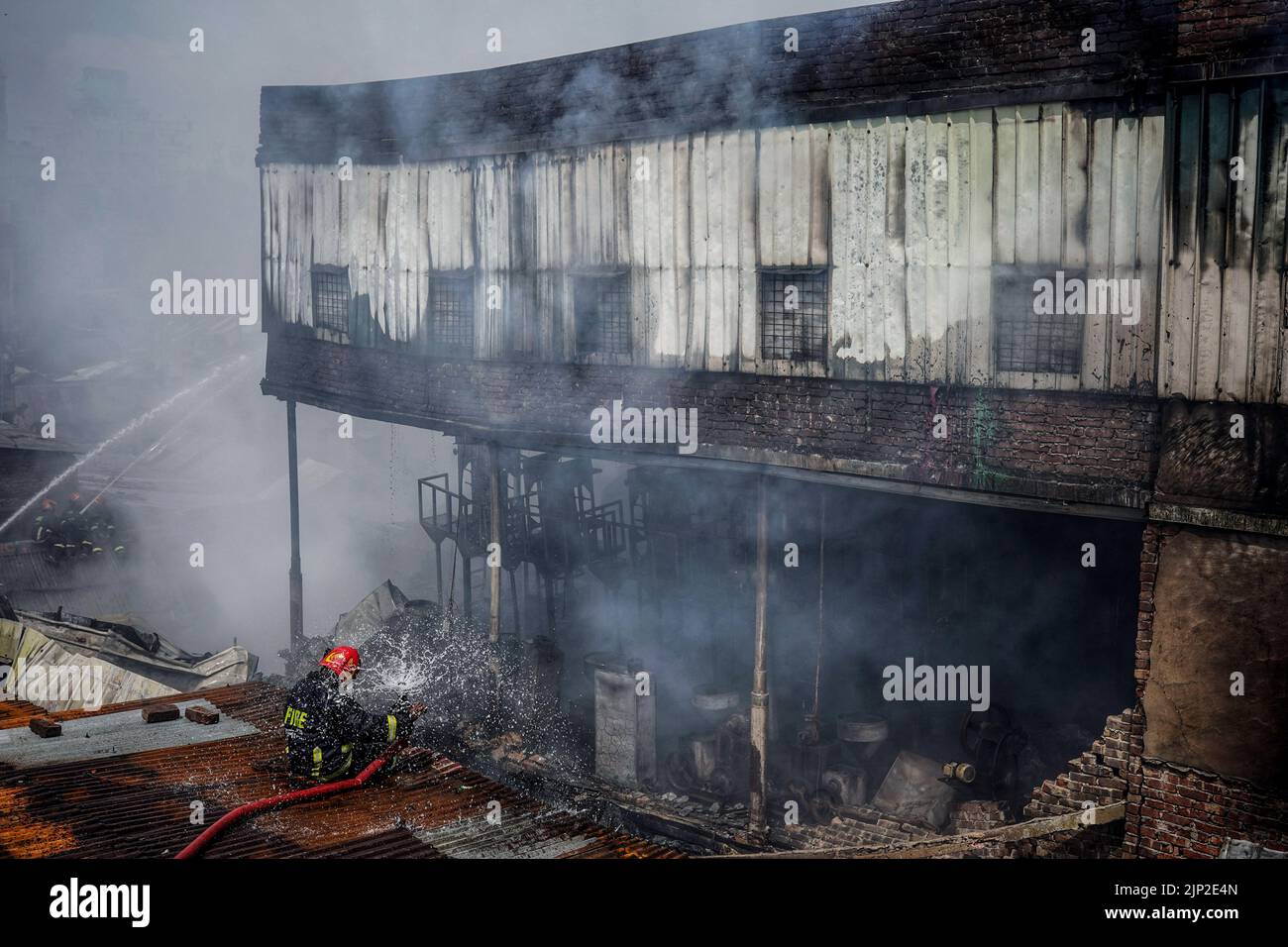 A firefighter tries to extinguish a fire inside the building at a ...