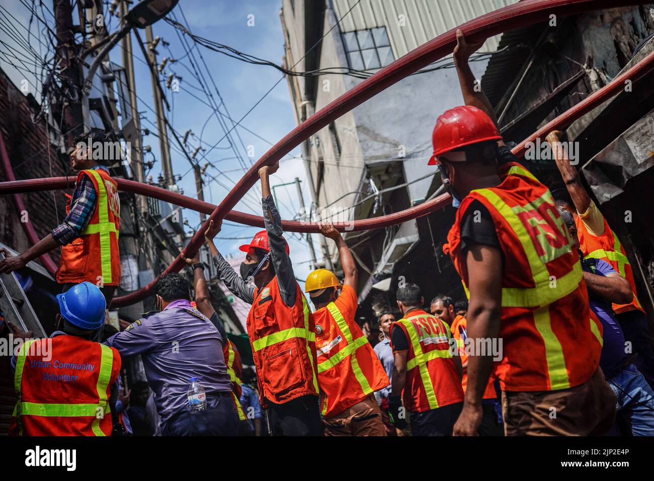 Volunteers help firefighters to extinguish a fire inside the building ...